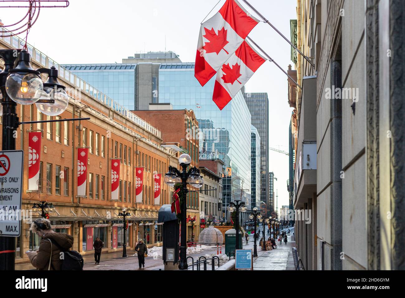 Ottawa, Canada - July 1, 2021: Cityscape with walking people and canadian flags on walls in ...