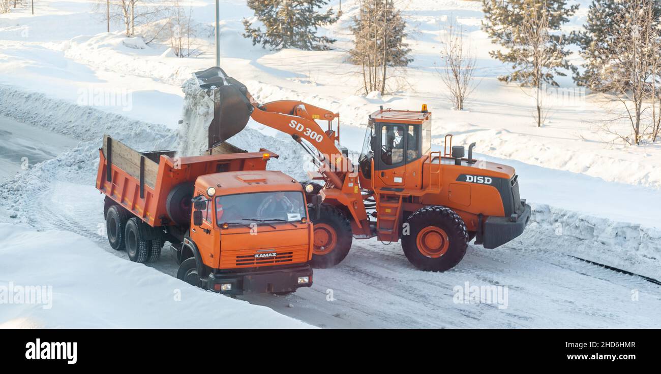 December 23, 2021. Kemerovo Region, Russia. Big orange tractor cleans ...