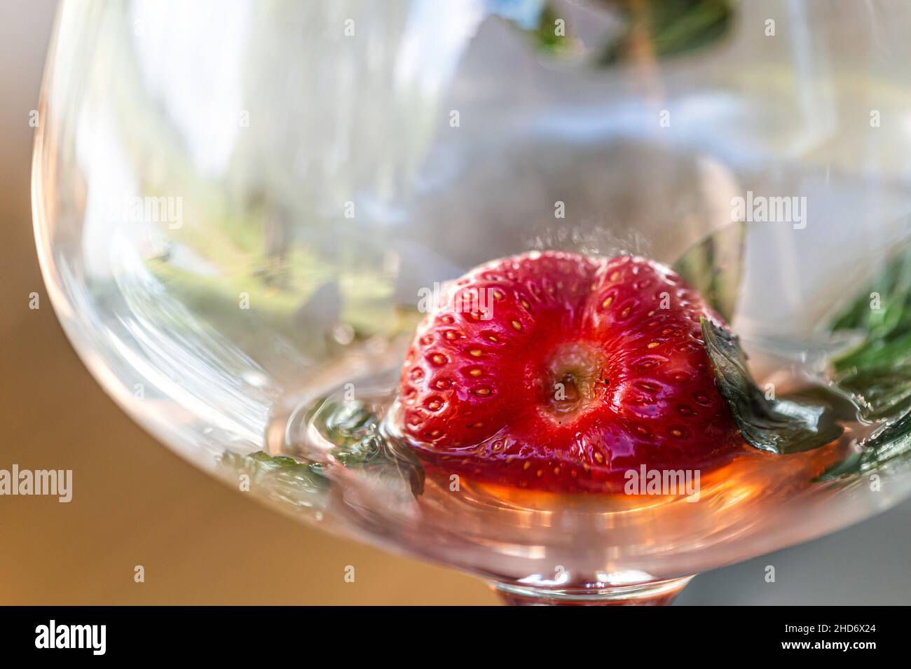 juicy red strawberry and mint leaves at the bottom of an empty cocktail ...