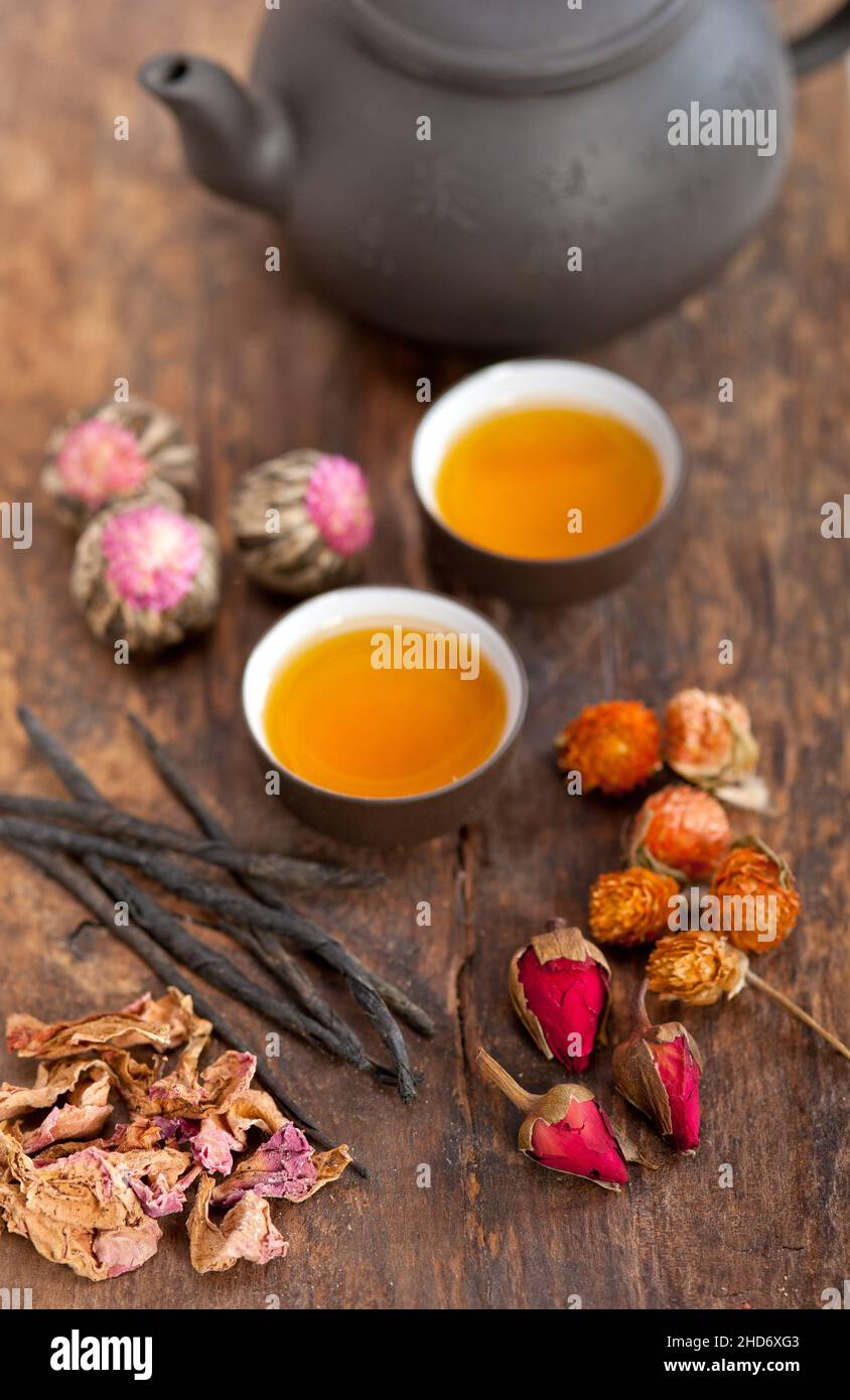 Chinese style herbal floral tea over wood table with raw ingredients ...