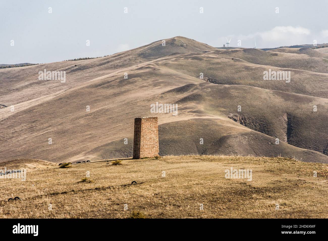 Brick structure in a field against a mountain Stock Photo - Alamy
