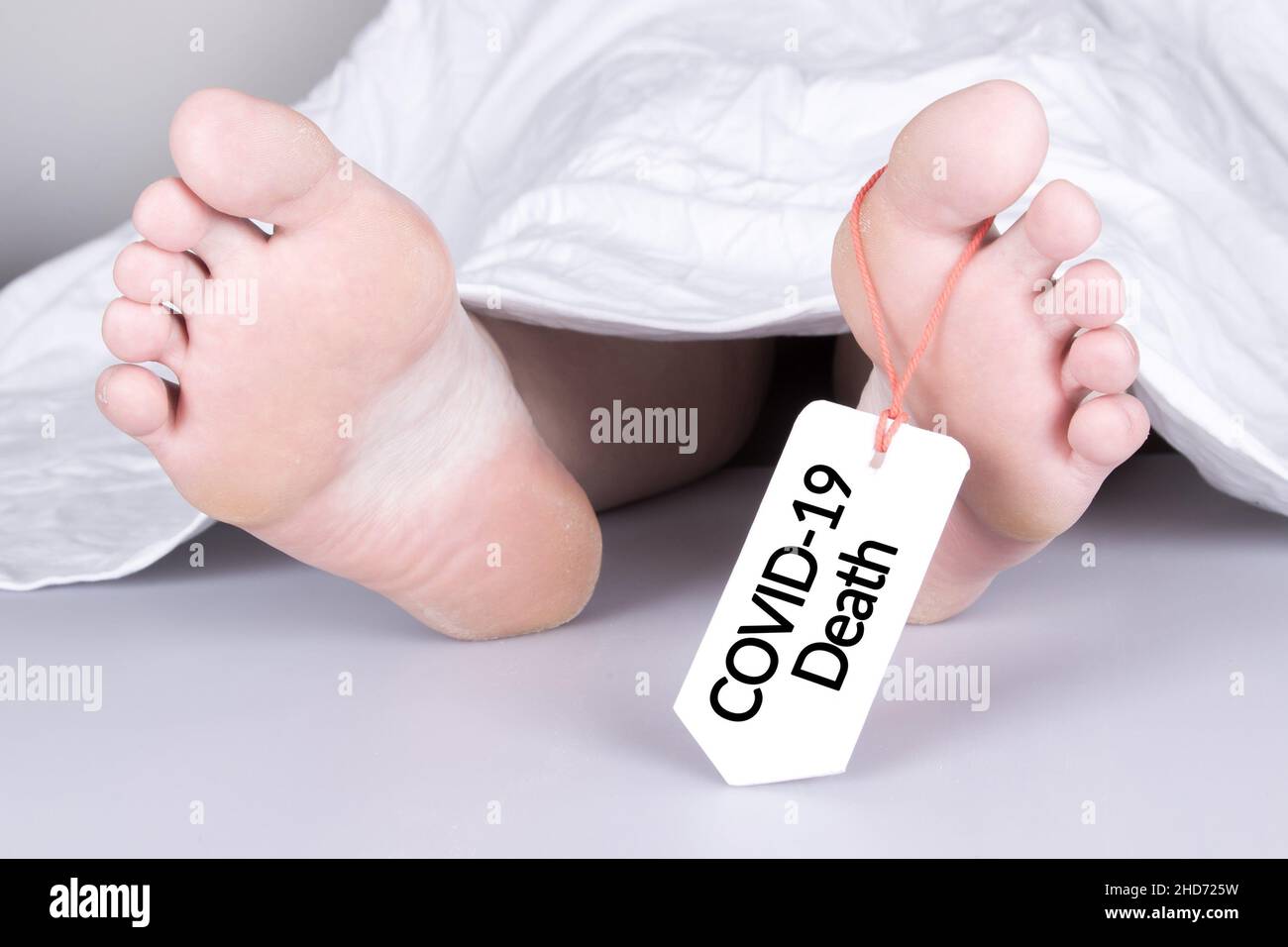 Body with toe tag on white, under a white sheet - Covid-19 death Stock ...