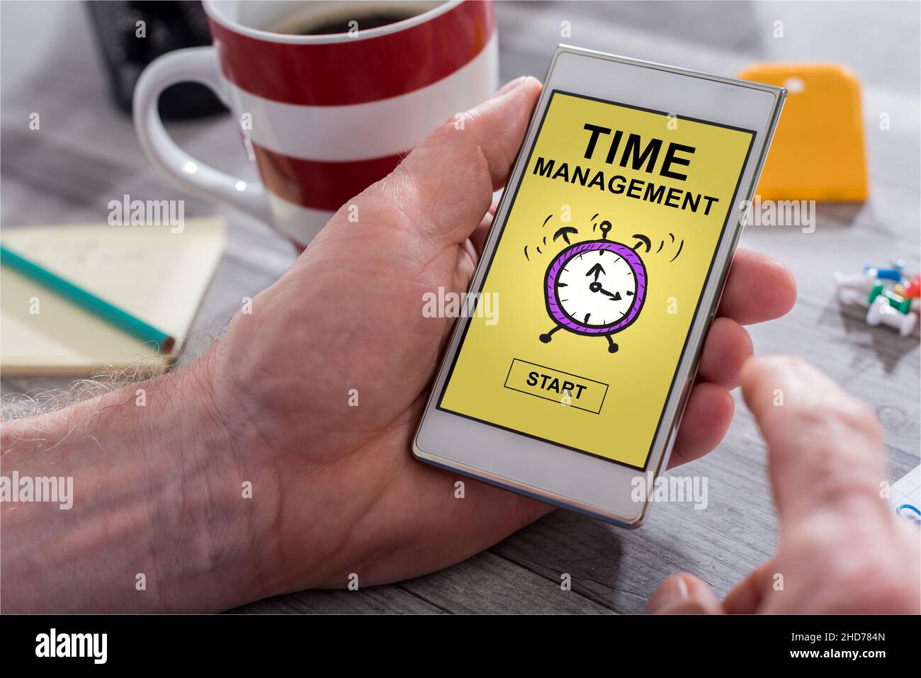 Male hand holding a smartphone with time management concept Stock Photo ...