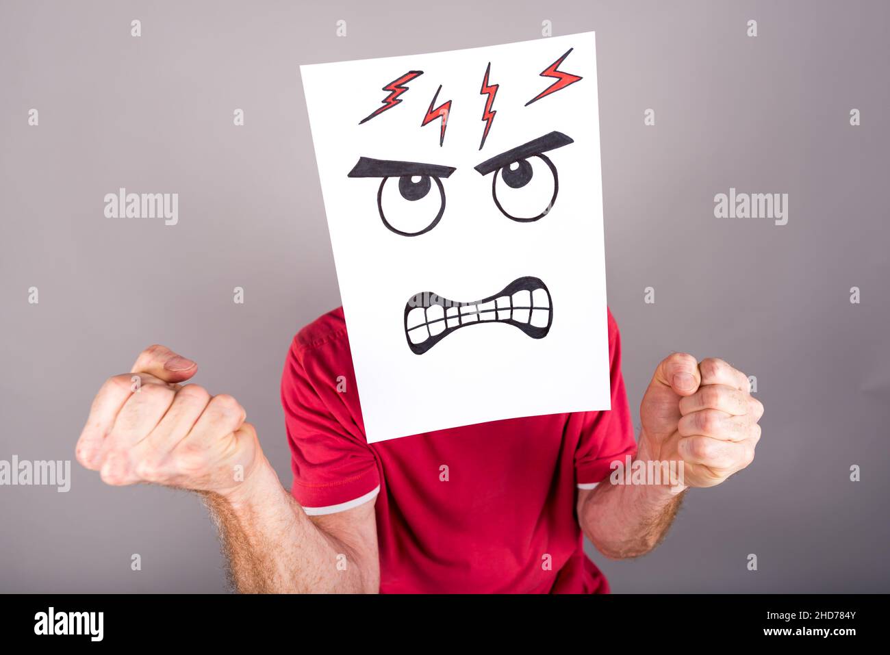 Man behind a paper with a anger expression Stock Photo - Alamy