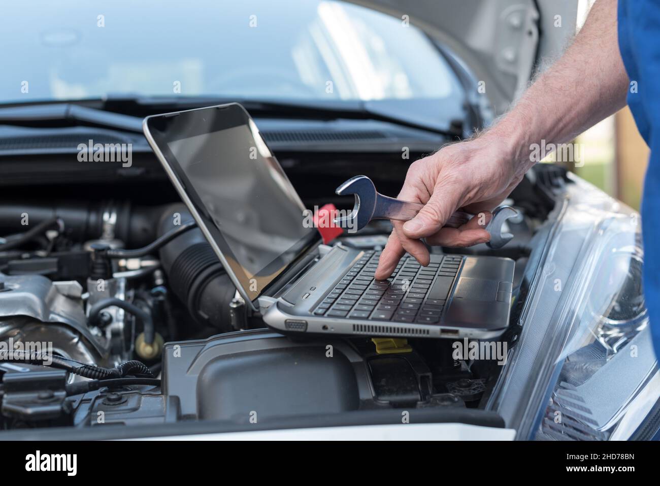 Car mechanic using laptop for checking car engine Stock Photo - Alamy