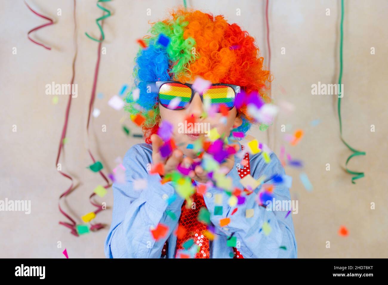 Funny boy blowing confetti at carnival Stock Photo - Alamy