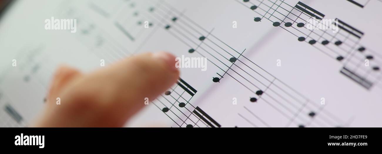 Woman finger points to musical notes. Classical music and music ...