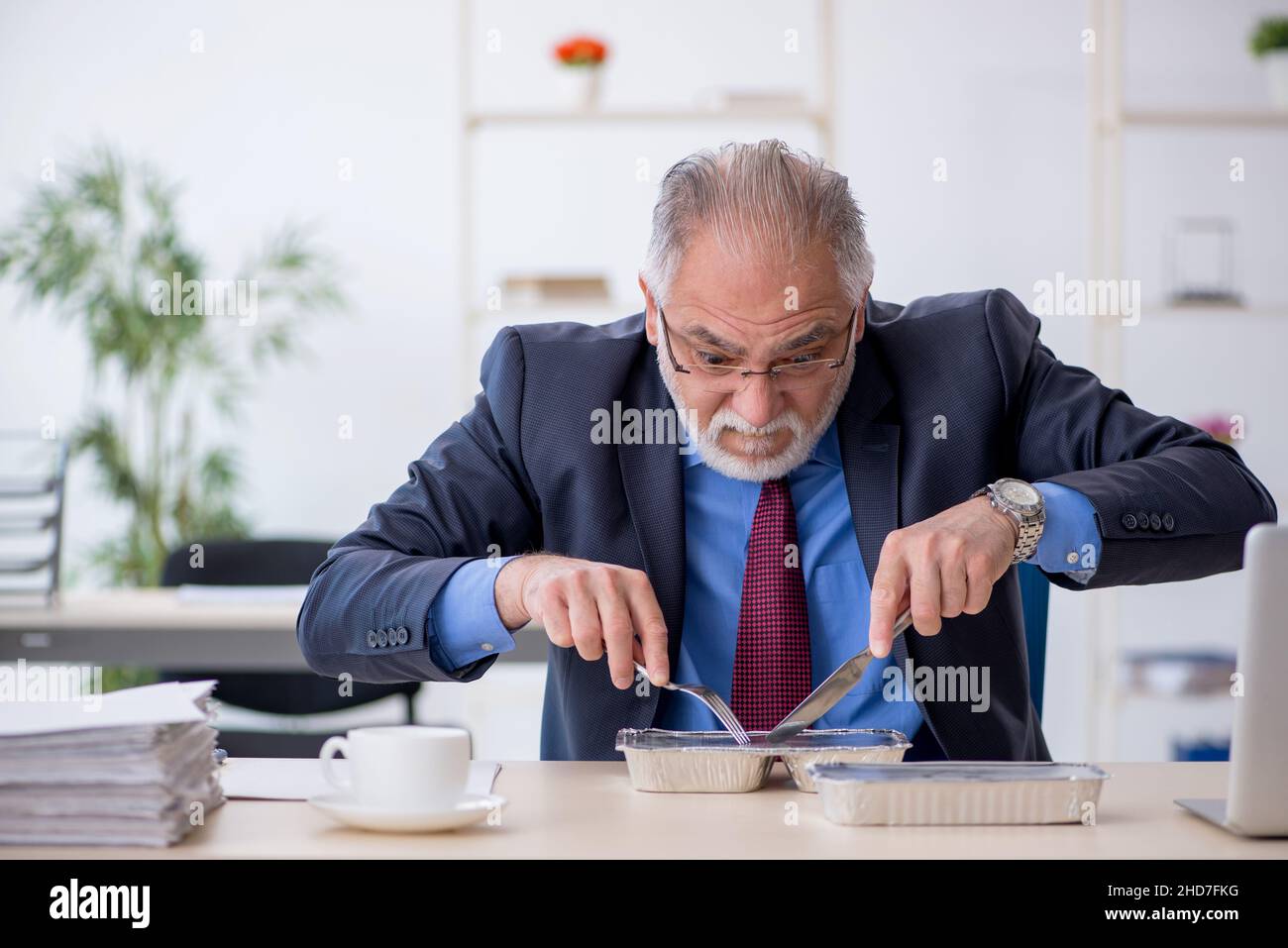 Old businessman employee having breakfast at workplace Stock Photo - Alamy