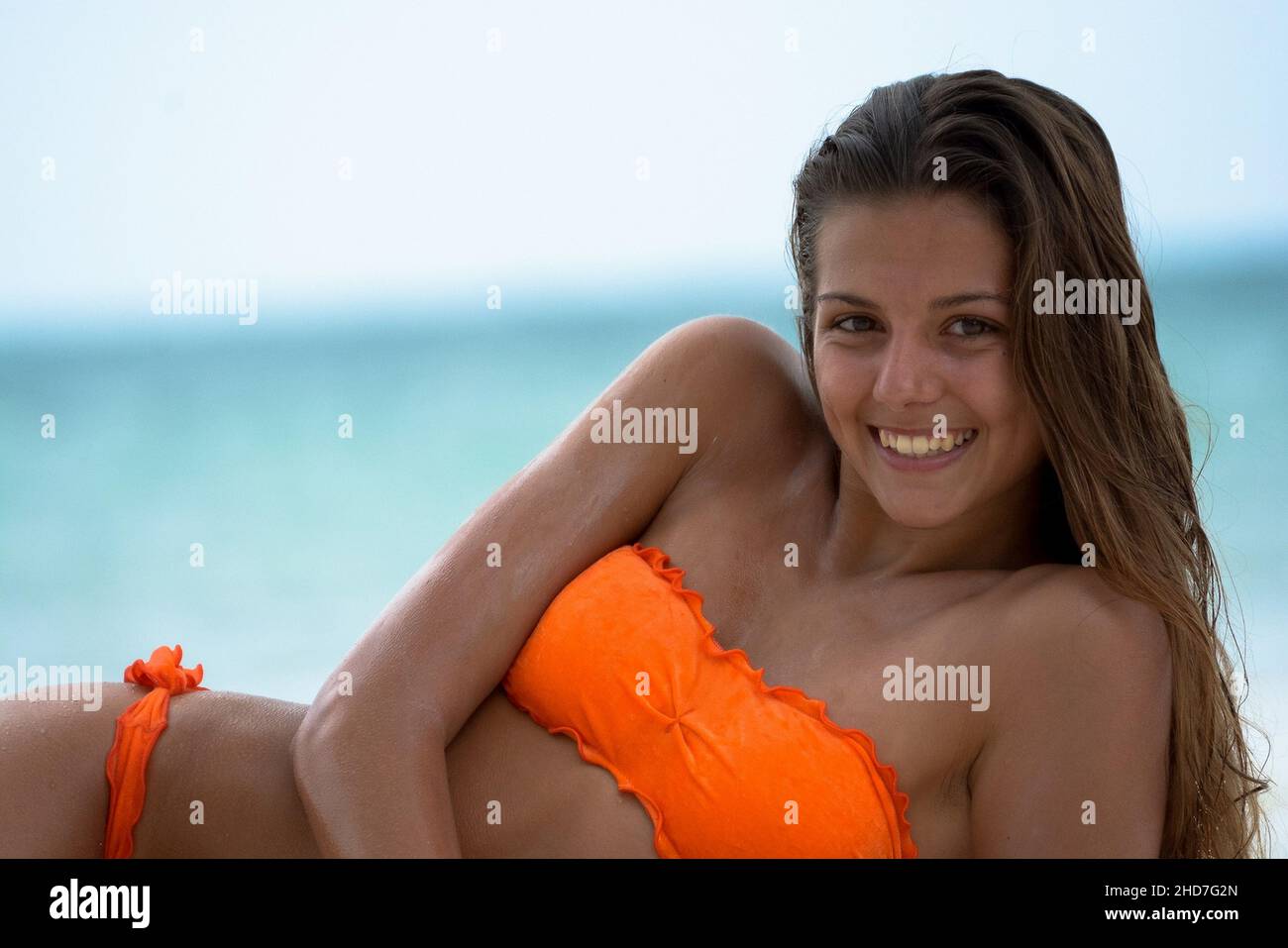 Portrait smiling young woman lying sand hi-res stock photography and images - Alamy
