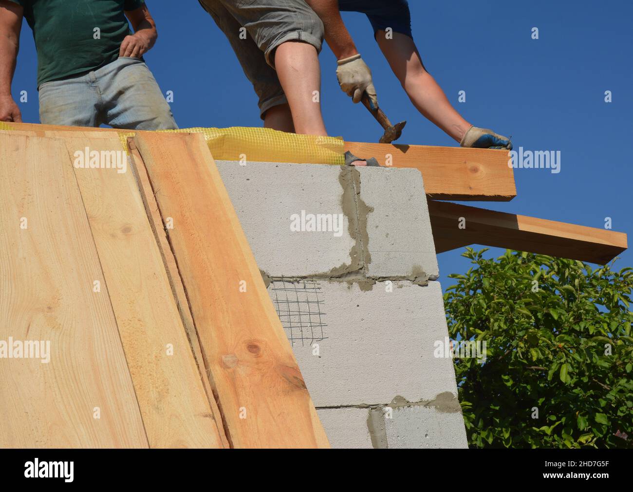 Roofing construction. The roofers are installing a wooden roof beam ...