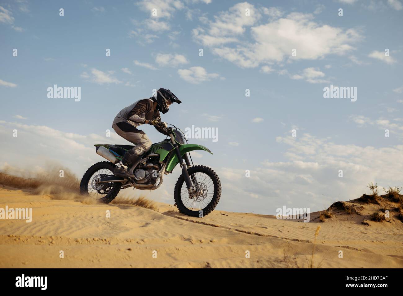 Professional motocross rider sliding down sand hill Stock Photo - Alamy