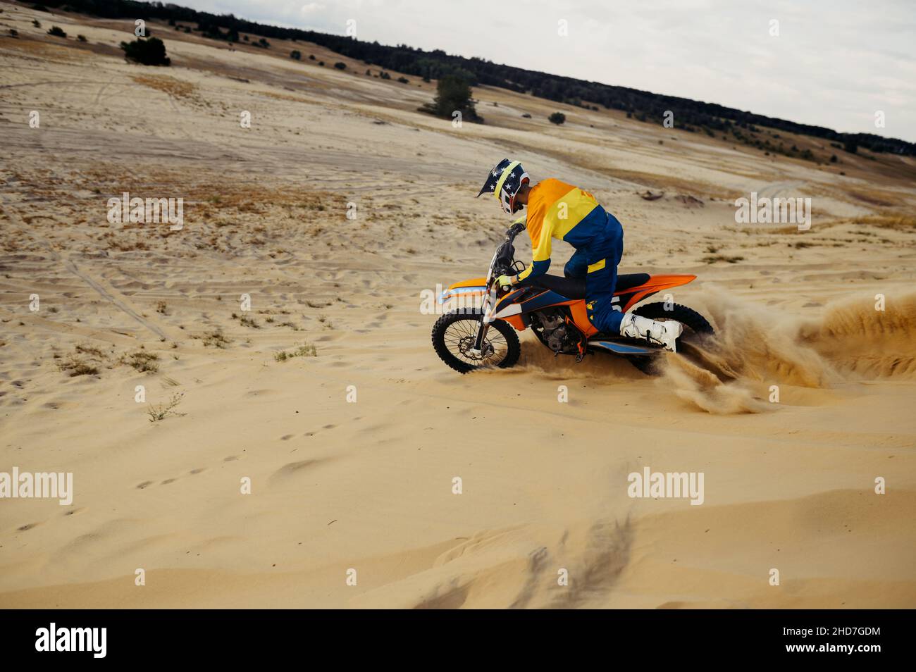 Professional motocross rider sliding down sand hill Stock Photo - Alamy