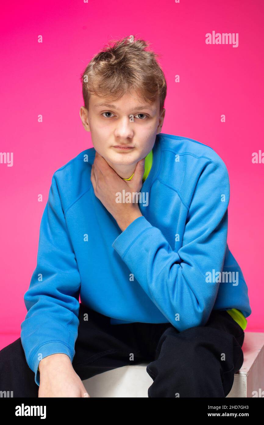 Young european boy with white skin isolated on pink in blue hoody ...