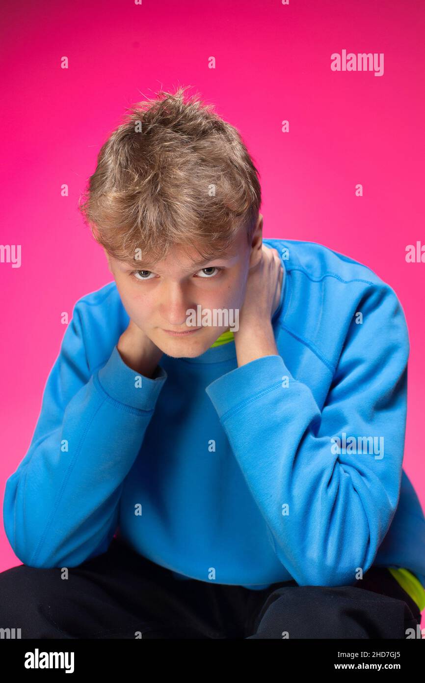 Young european boy with white skin isolated on pink in blue hoody with ...