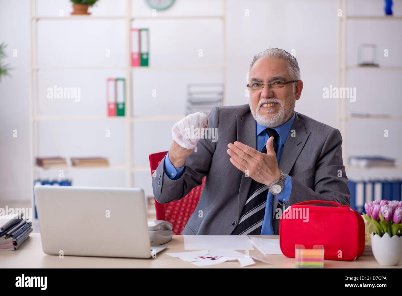 Old businessman employee cutting his hand at workplace Stock Photo - Alamy