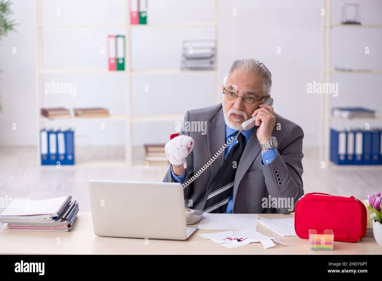 Old businessman employee cutting his hand at workplace Stock Photo - Alamy