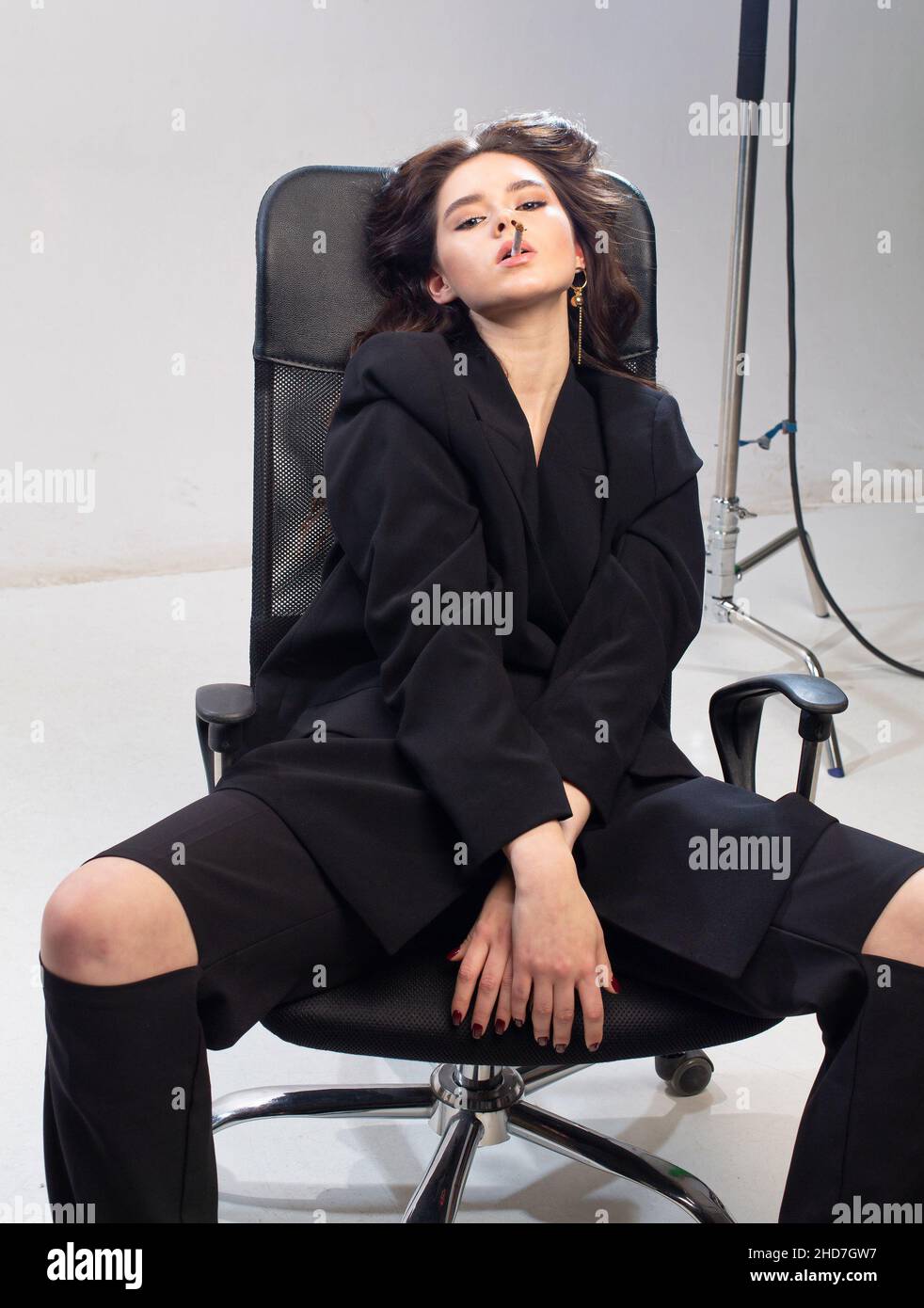 Smoking dark hair young european girl with white skin in office chair ...