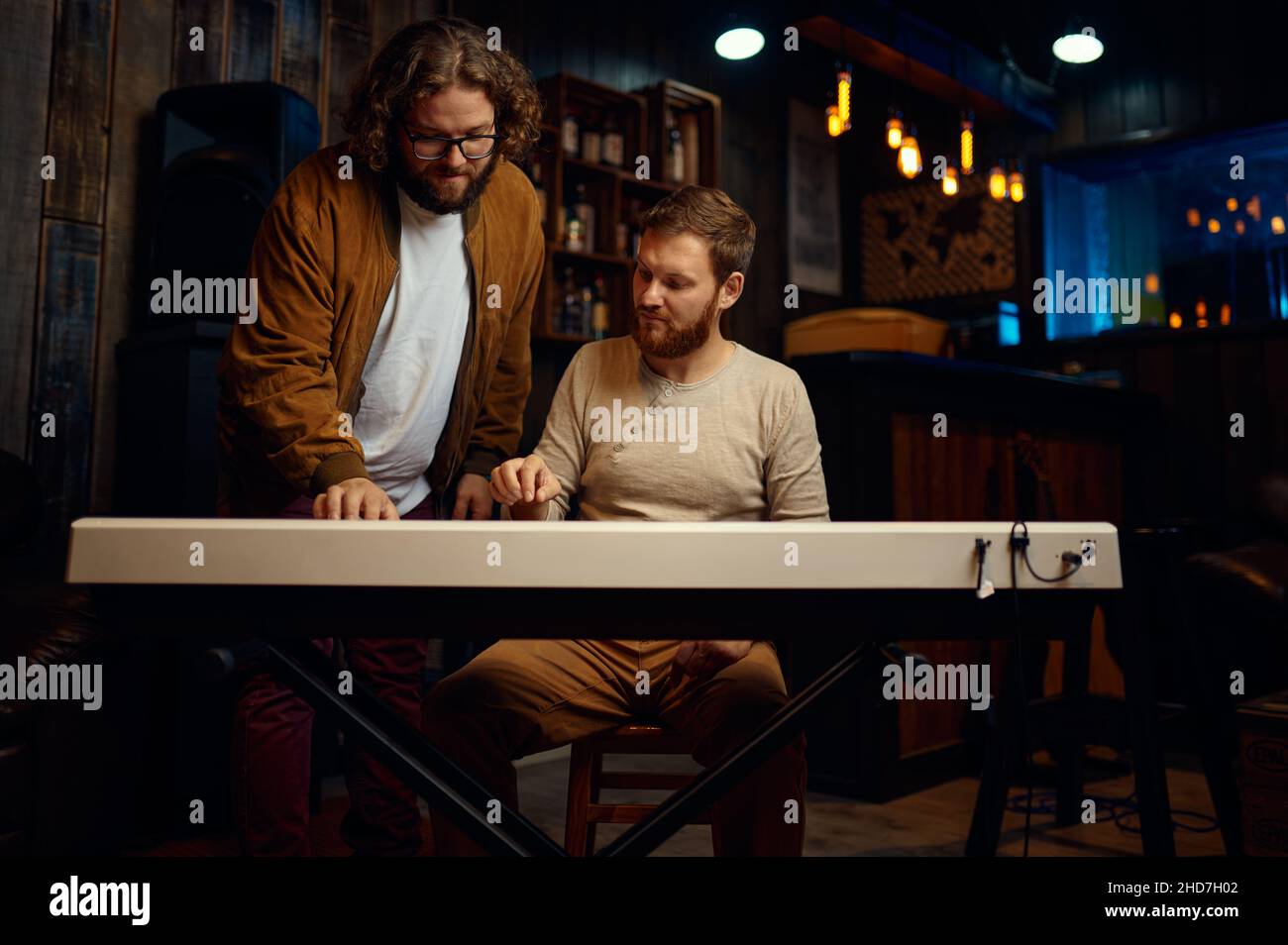 Teacher and student playing synthesizer during lesson Stock Photo - Alamy