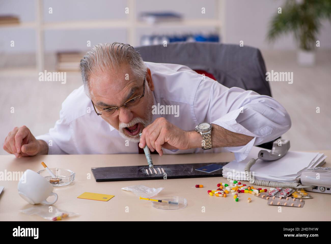 Old male drug addicted employee sitting at workplace Stock Photo - Alamy
