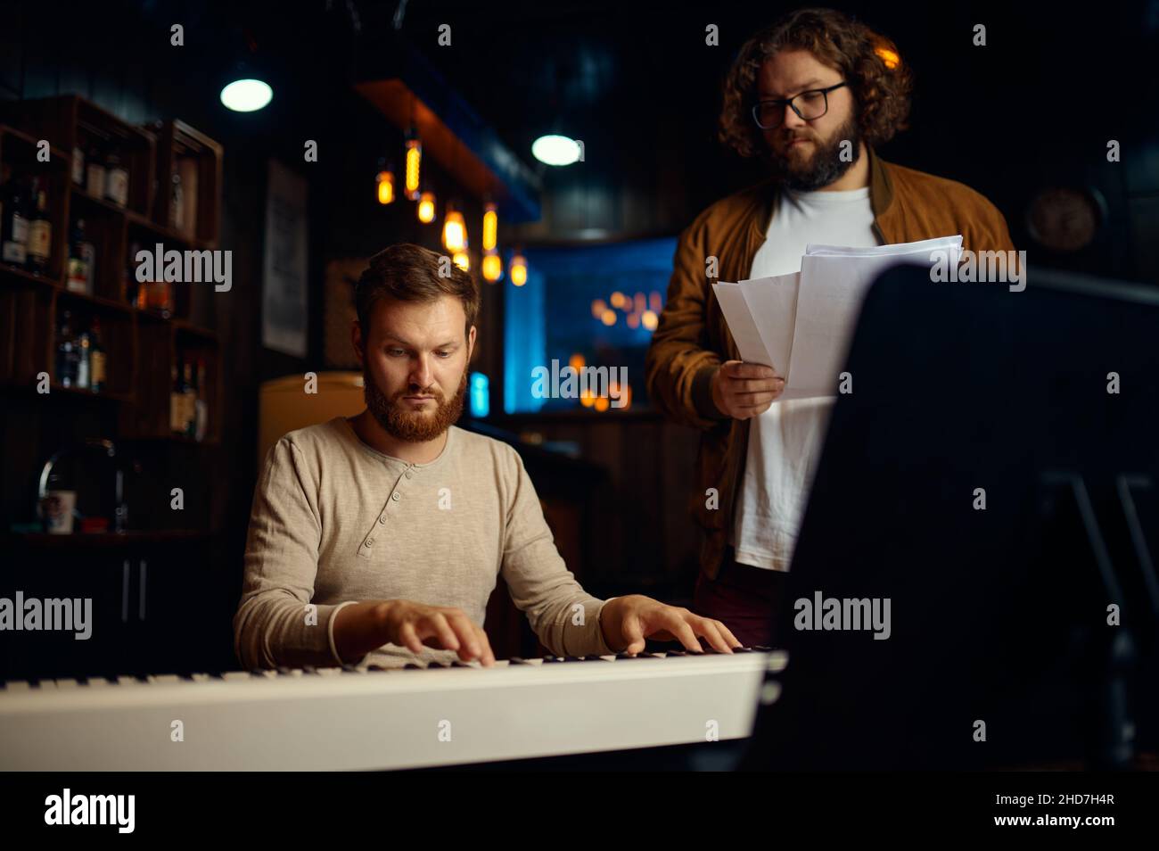 Tutor teaching young guy playing piano synthesizer Stock Photo - Alamy