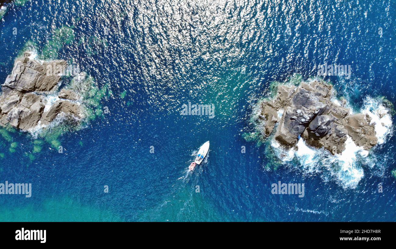 Aerial photograph of rocks and a boat out to sea outside the harbour of ...