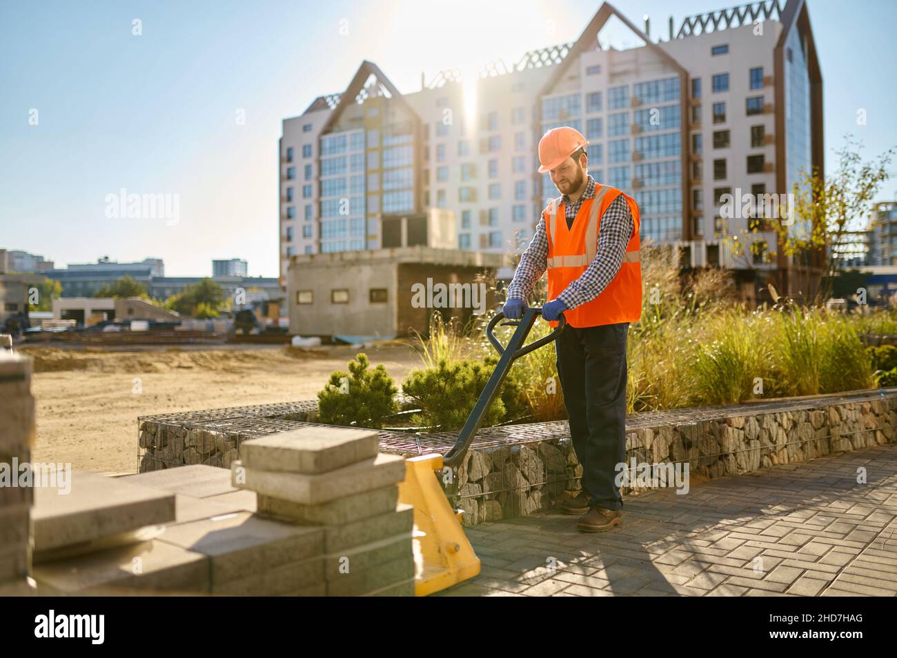 Builder using hand loader at construction site Stock Photo - Alamy