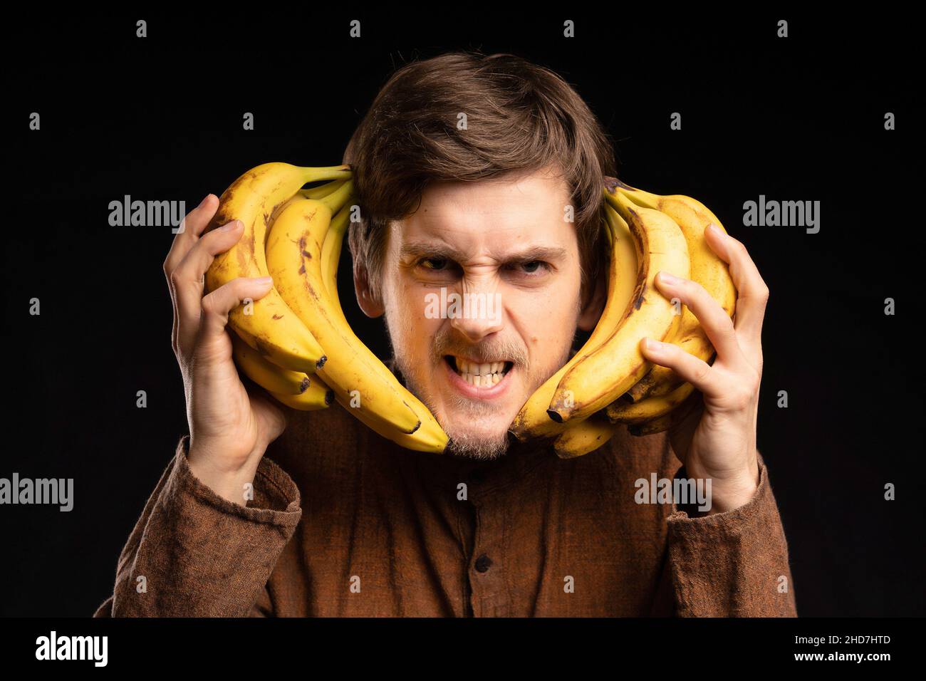 Young handsome tall slim white man with brown hair holding bananas next ...