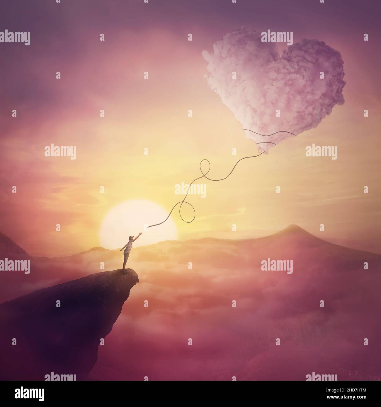 A person on the cliff and a heart shaped cloud like a kite raising up ...