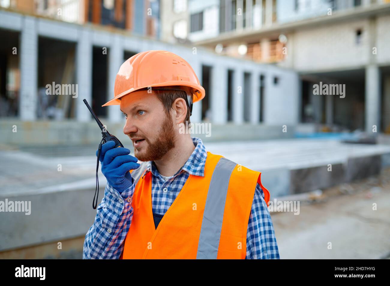 Builder worker using walkie-talkie on construction site Stock Photo - Alamy