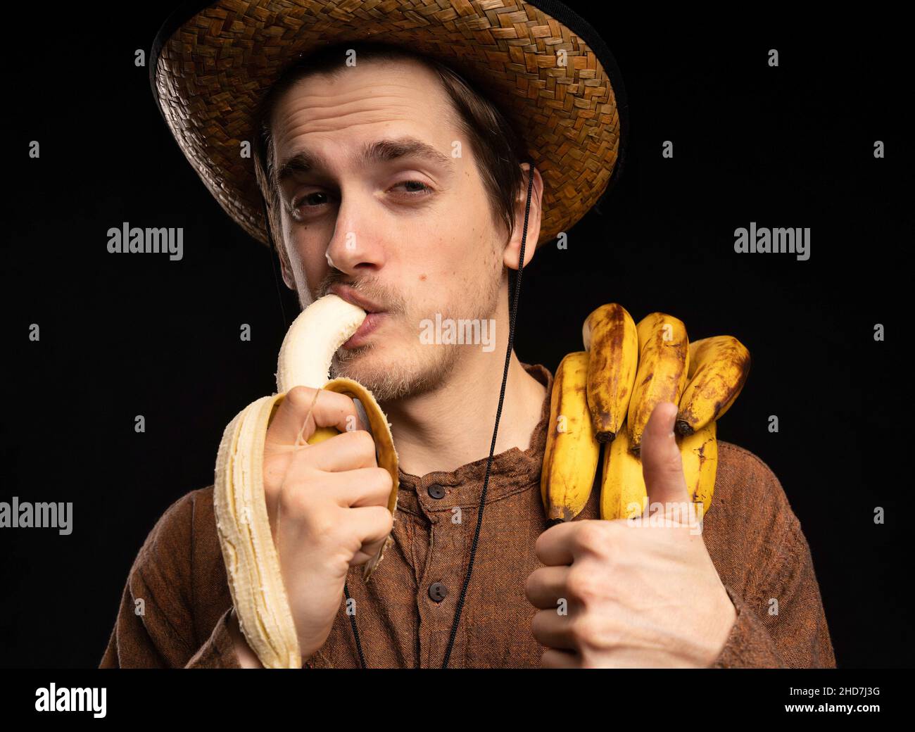 Young handsome tall slim white man with brown hair biting banana eyes ...