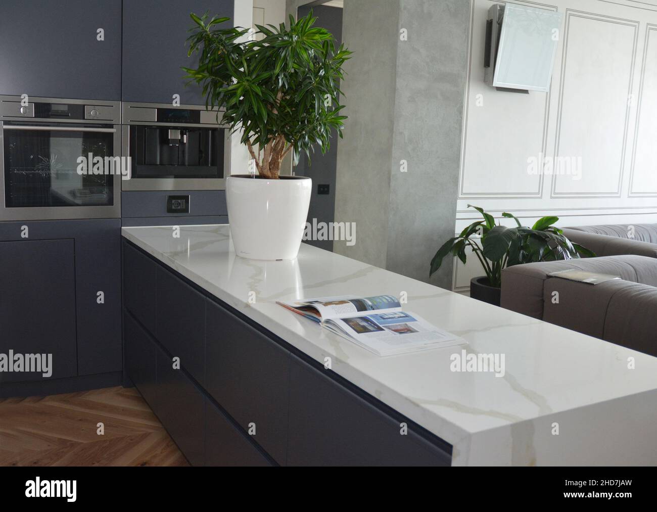 Modern kitchen design with a kitchen island with a white surface and a ...