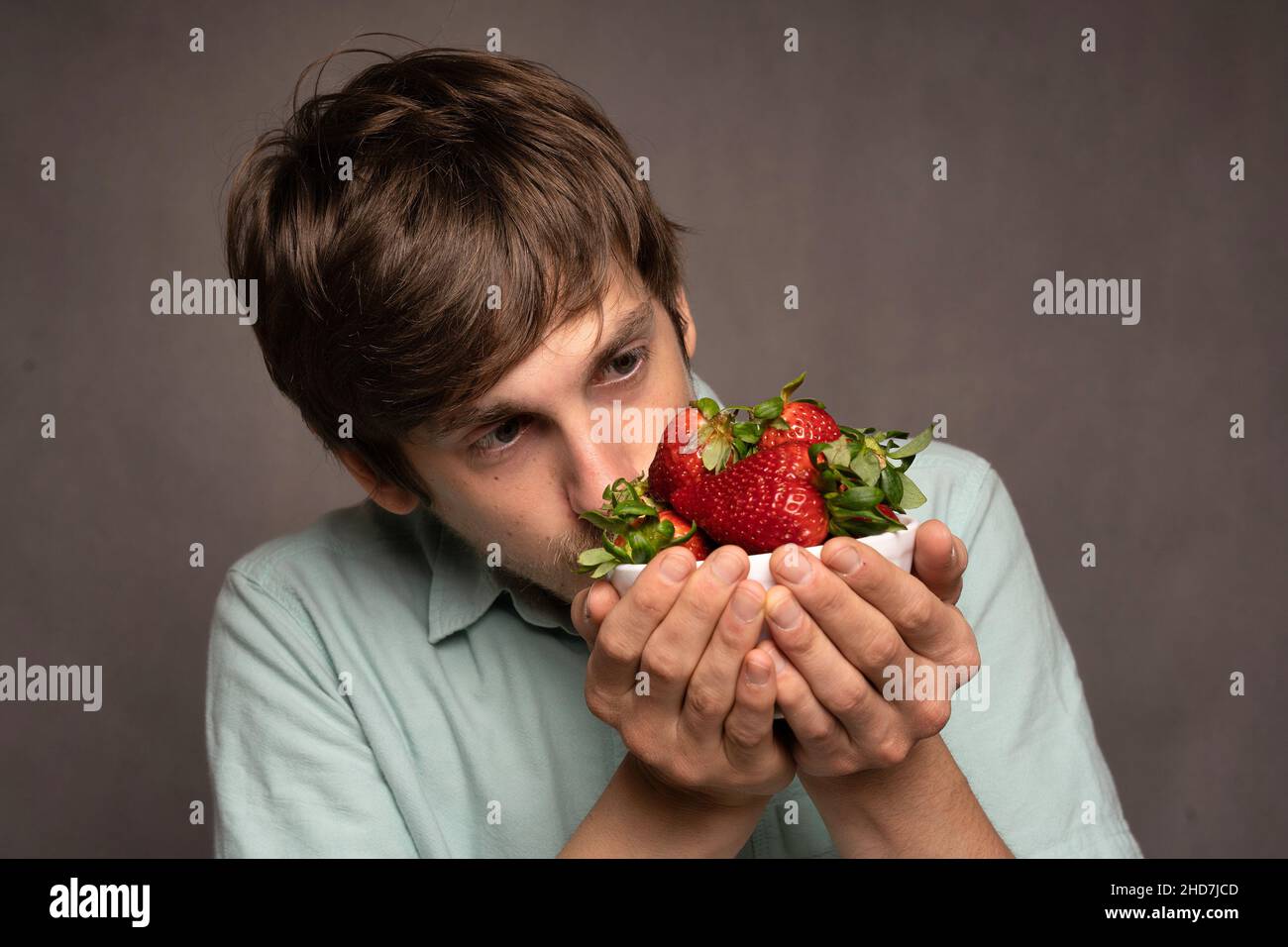 Young handsome tall slim white man with brown hair closely observing ...