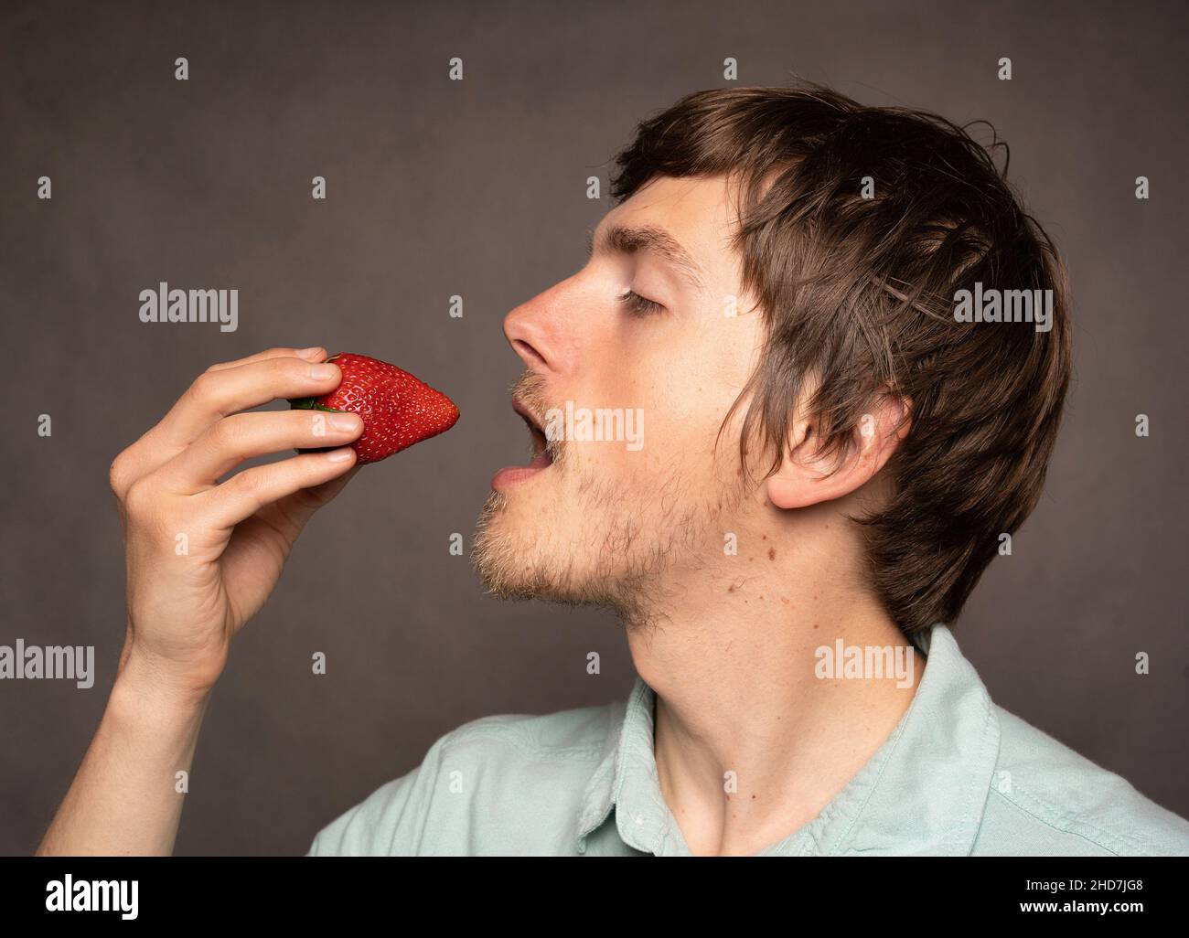 Young handsome tall slim white man with brown hair about to taste ...