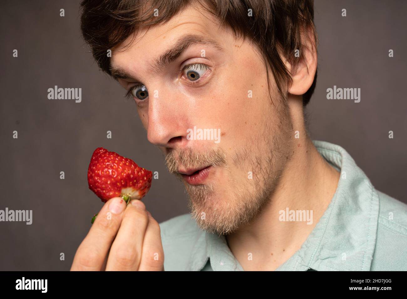 Young handsome tall slim white man with brown hair holding half eaten ...