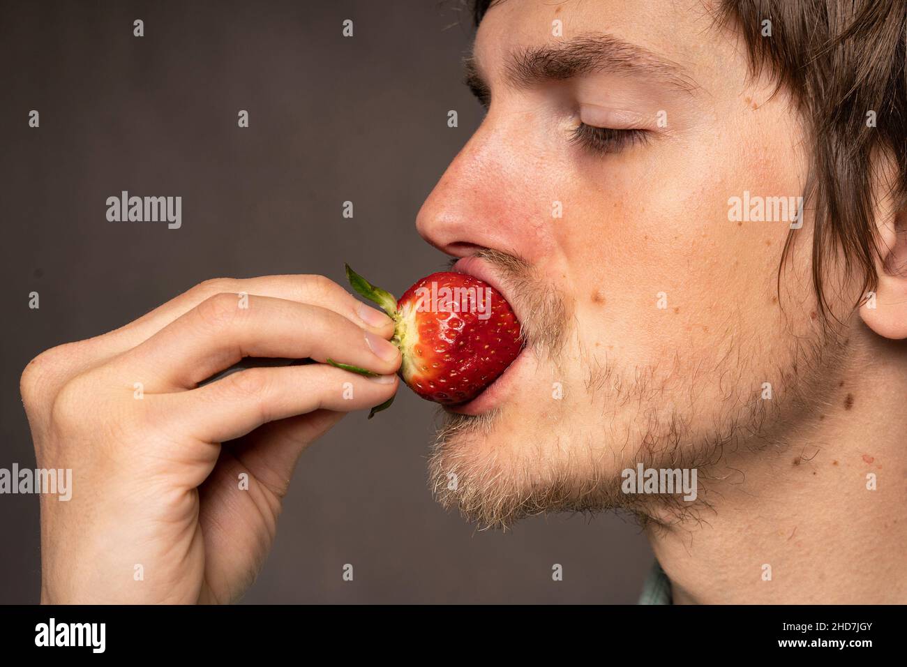 Young handsome tall slim white man with brown hair enjoying the taste ...
