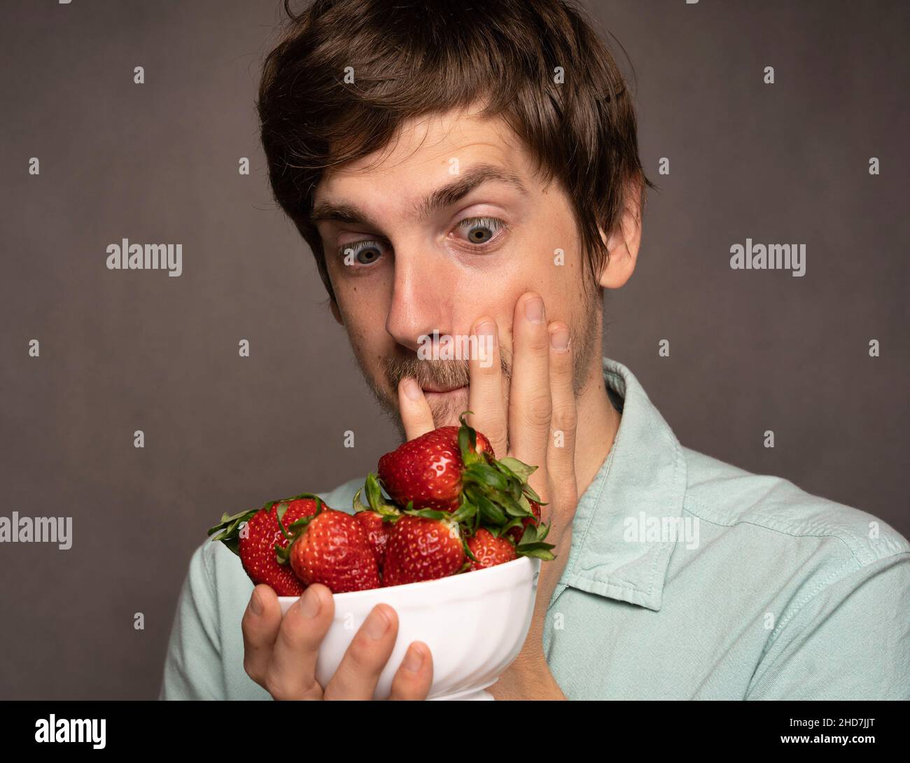 Young handsome tall slim white man with brown hair holding his face ...