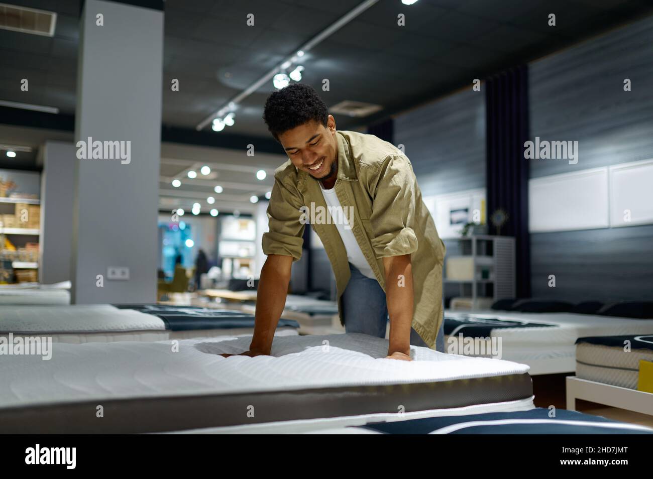 Man choosing bed checking orthopedic mattress softness Stock Photo - Alamy