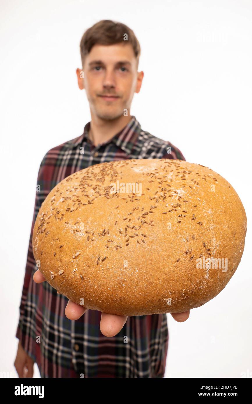 Young handsome tall slim white man with brown hair offering you loaf of ...