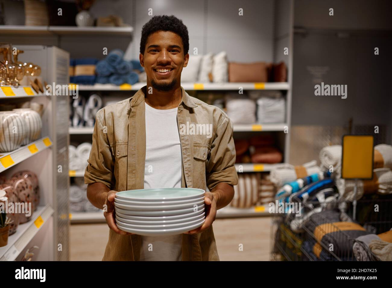 Portrait of man carrying purchased plate stack Stock Photo - Alamy