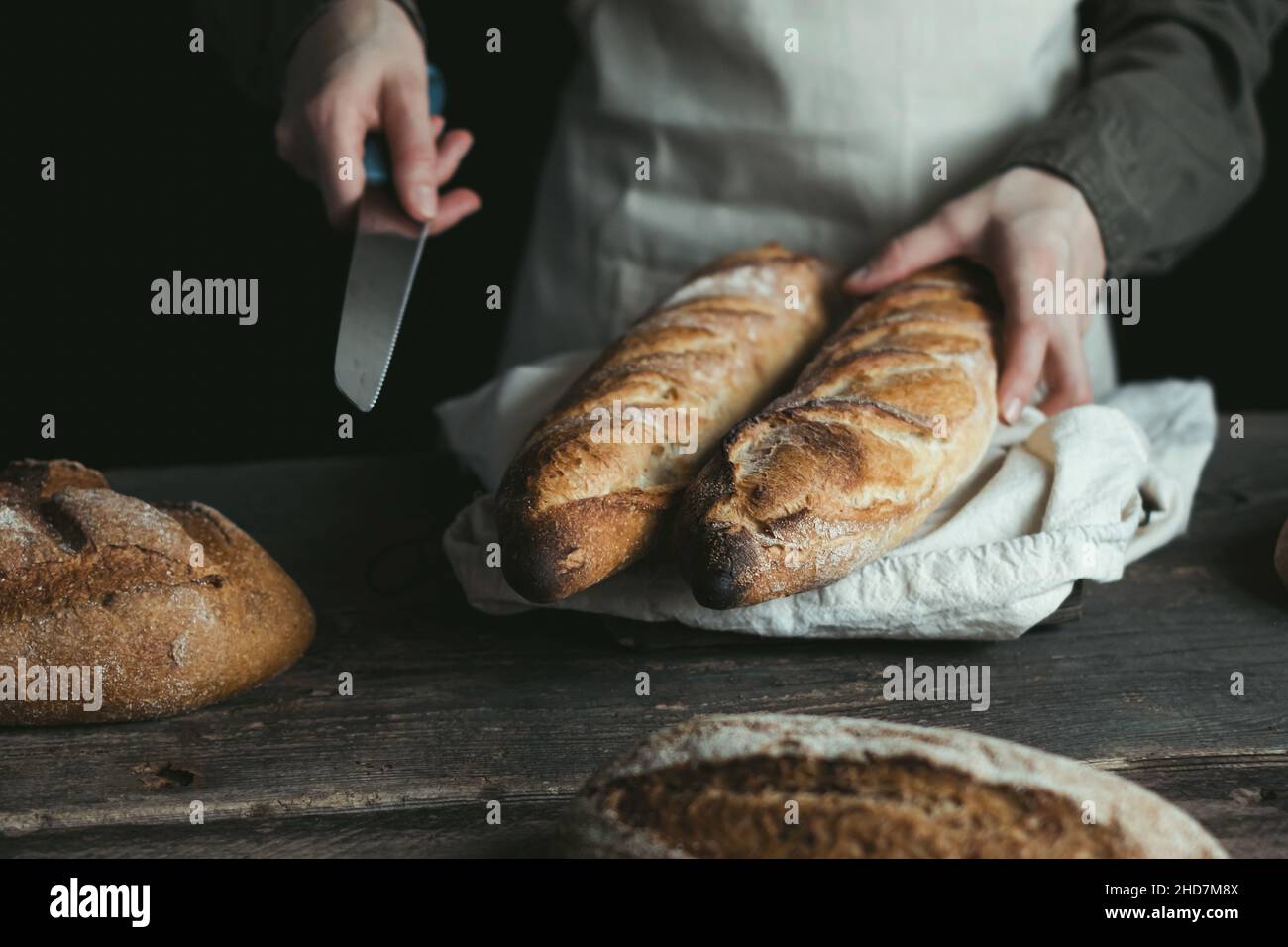 Rye bread. Female hands are going to cut a loaf. Bread without yeast ...