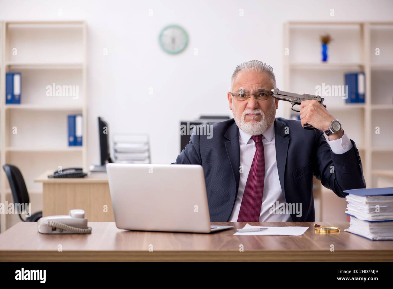 Old male employee holding gun at workplace Stock Photo - Alamy