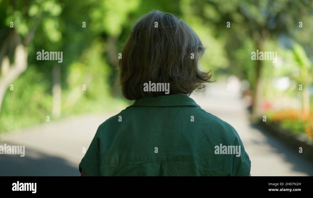 Back of person walking in nature, senior man in 60s in green path Stock ...