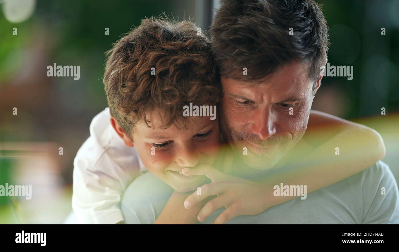 Child kissing father on the cheek, candid and real life family love and ...