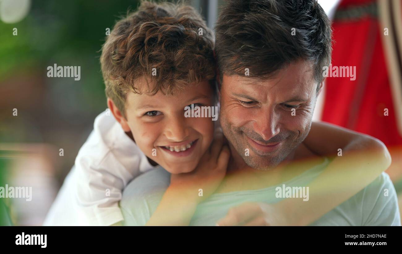 Child kissing father on the cheek, candid and real life family love and ...