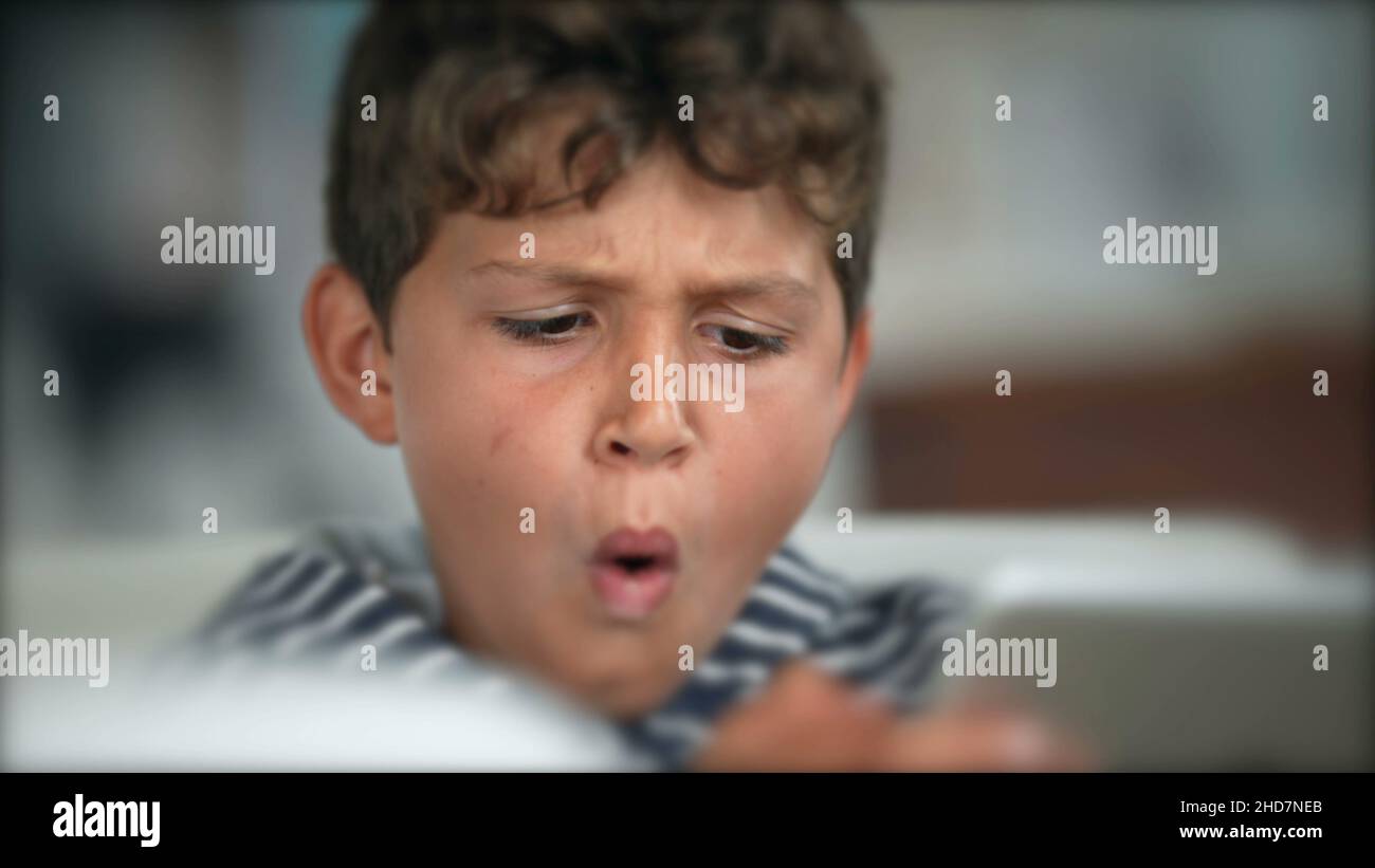 Child surprised reaction holding tablet. Boy WOW face emotion Stock ...