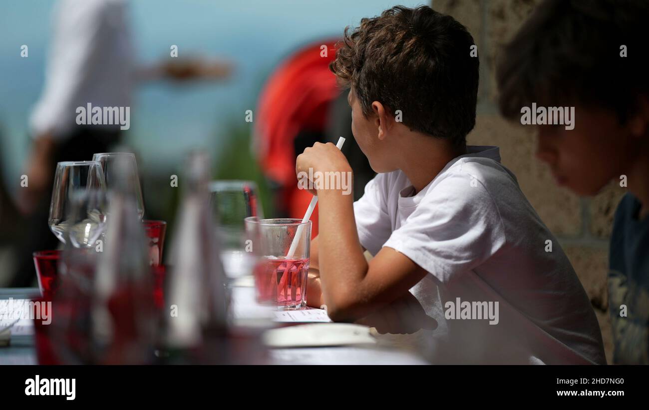 Children sitting at restaurant table, kid drinking from straw Stock ...