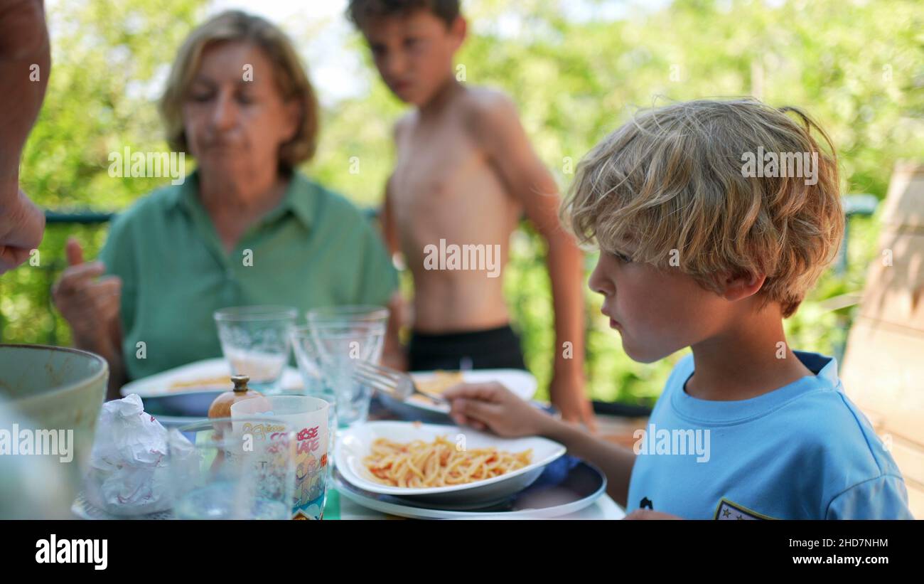 Family eating lunch outside gathered together during meal Stock Photo ...