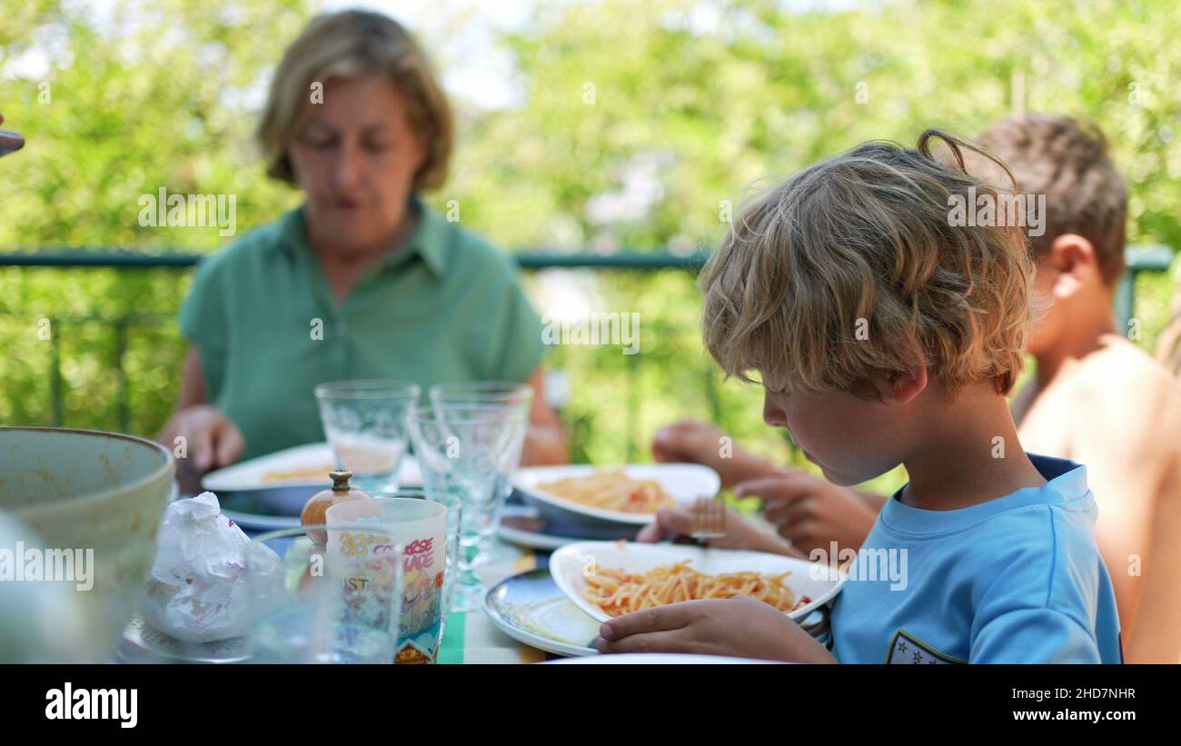 Family eating lunch outside gathered together during meal Stock Photo ...