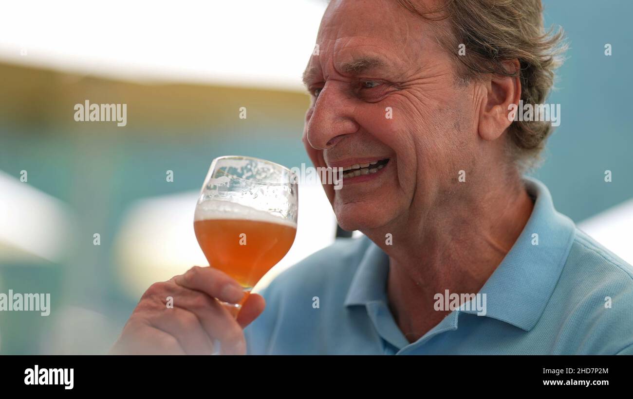 Happy senior man drinking beer with friends in conversation Stock Photo ...