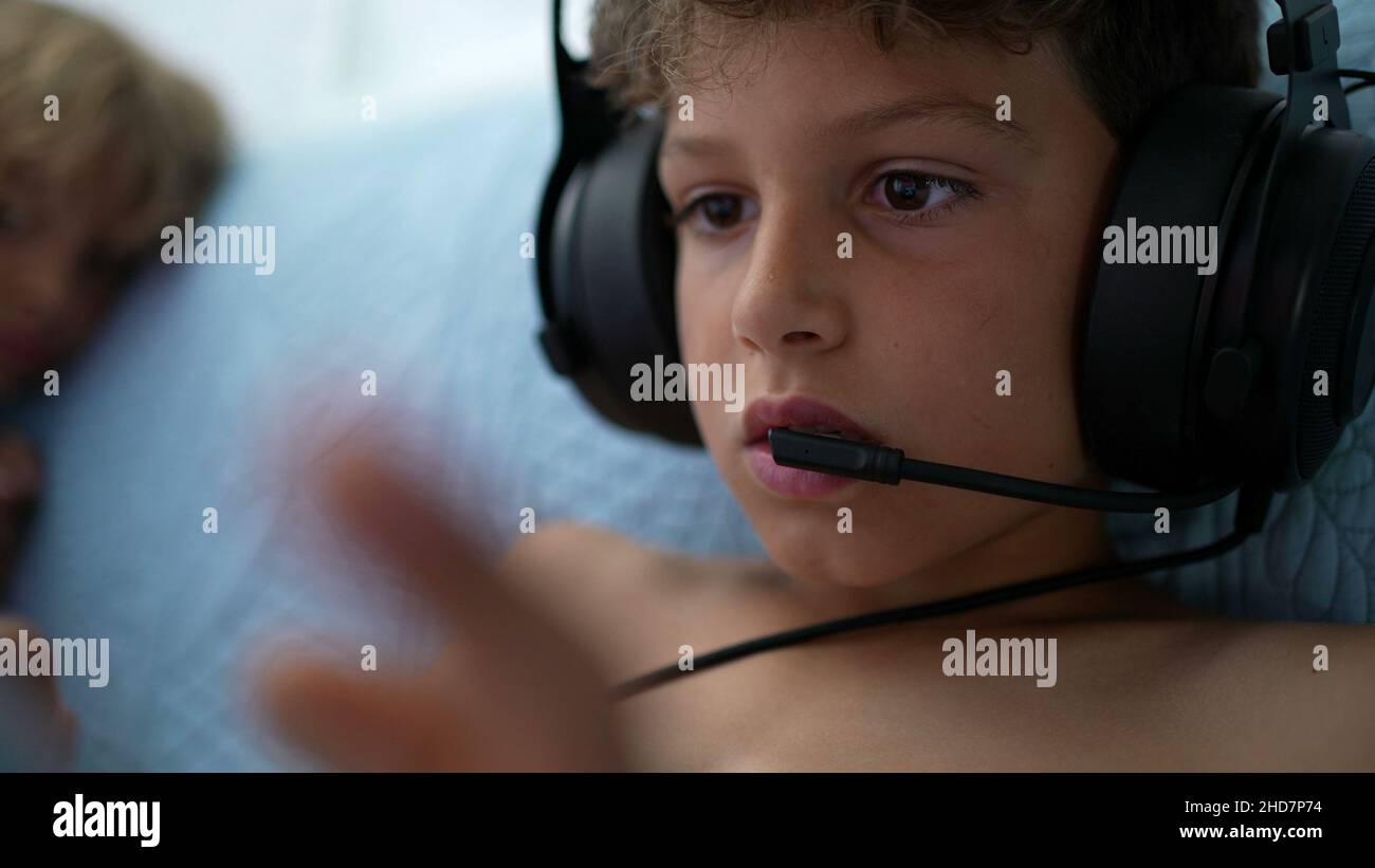 Kid playing video-game on tablet device. Boy touching screen plays ...